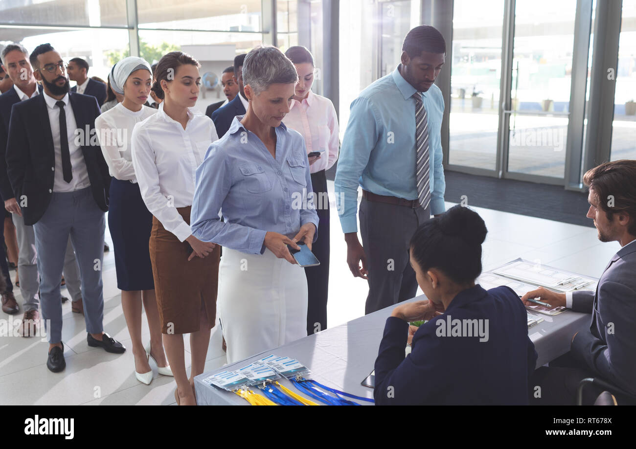 Business people checking in at conference registration table Stock ...