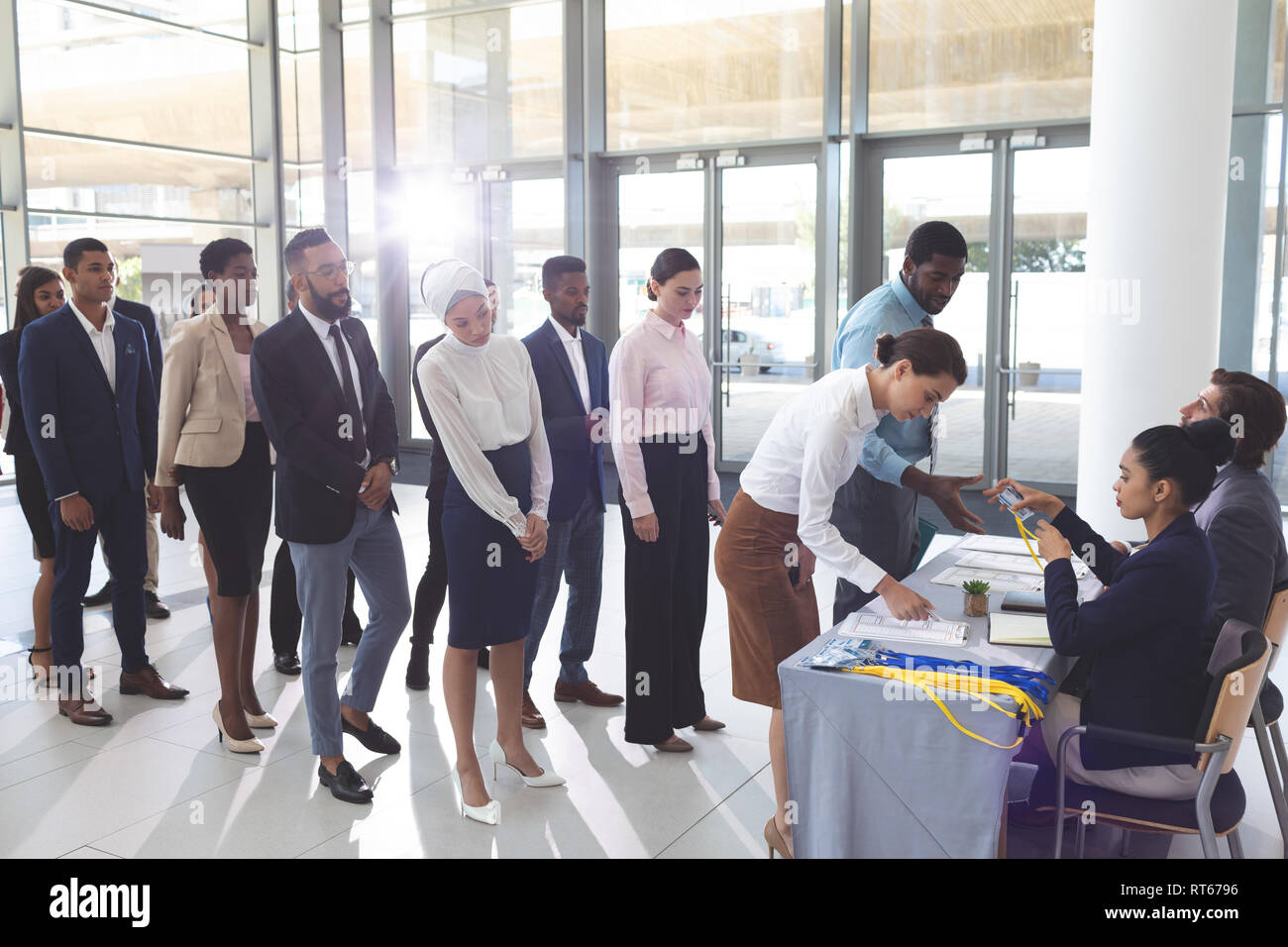 Business people checking in at conference registration table Stock ...