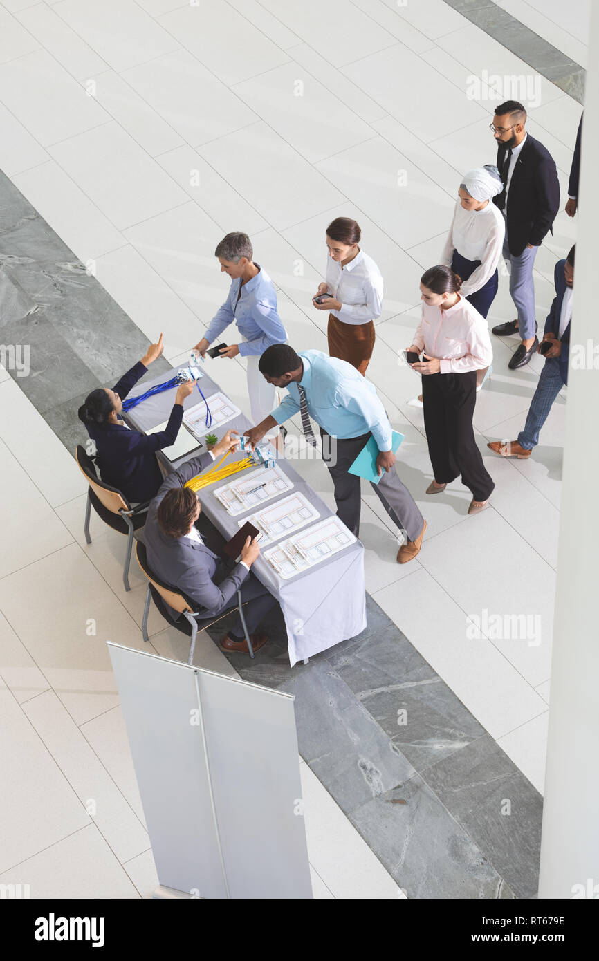 Business people checking in at conference registration table Stock ...
