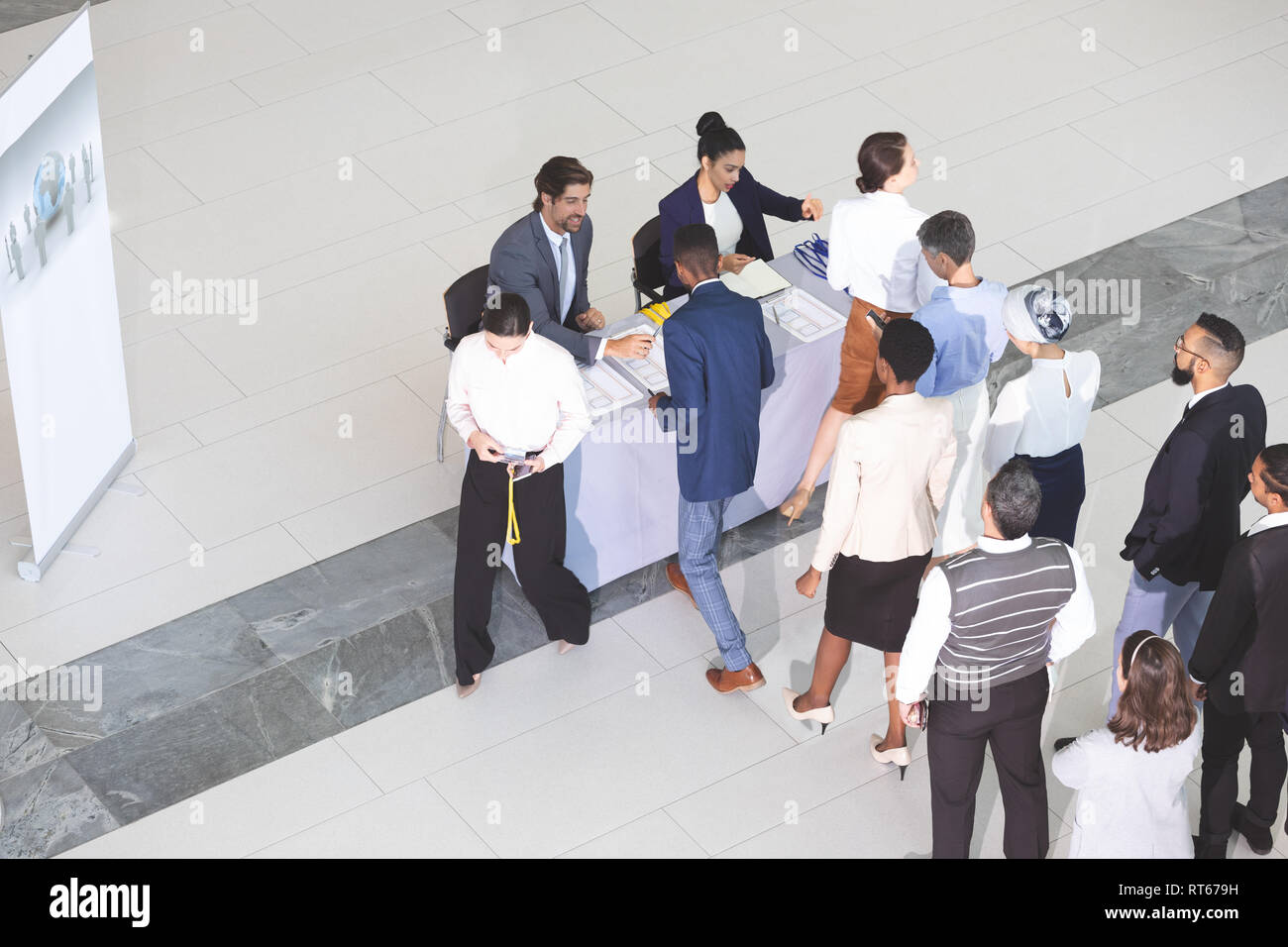 Business people checking in at conference registration table Stock ...