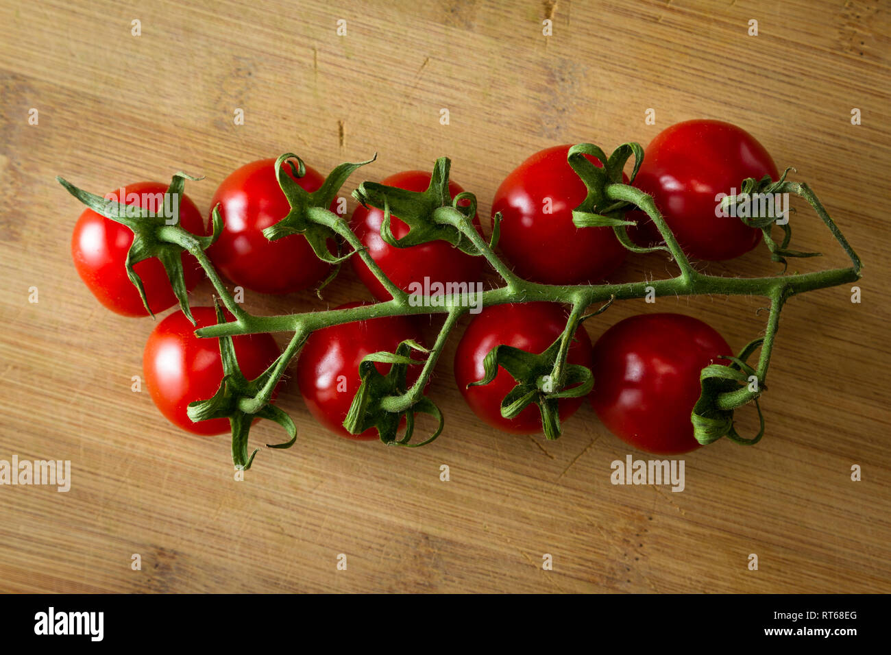 close up of a group of vine ripened strawberry tomatoes with a vibrant ...