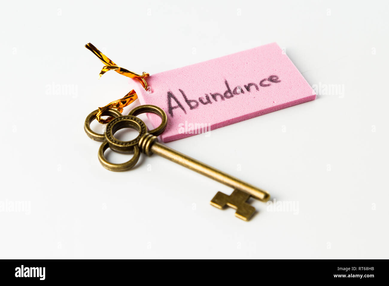 Close up of an ornamental key with the word abundance hand written on a ...