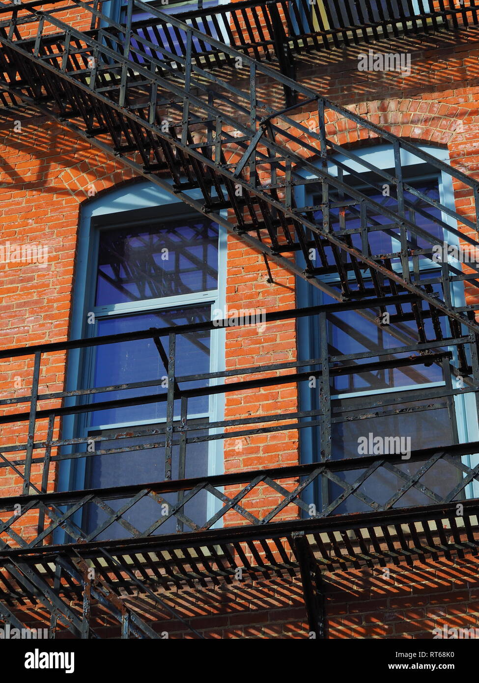 Fire escape on brick building covering windows Stock Photo - Alamy