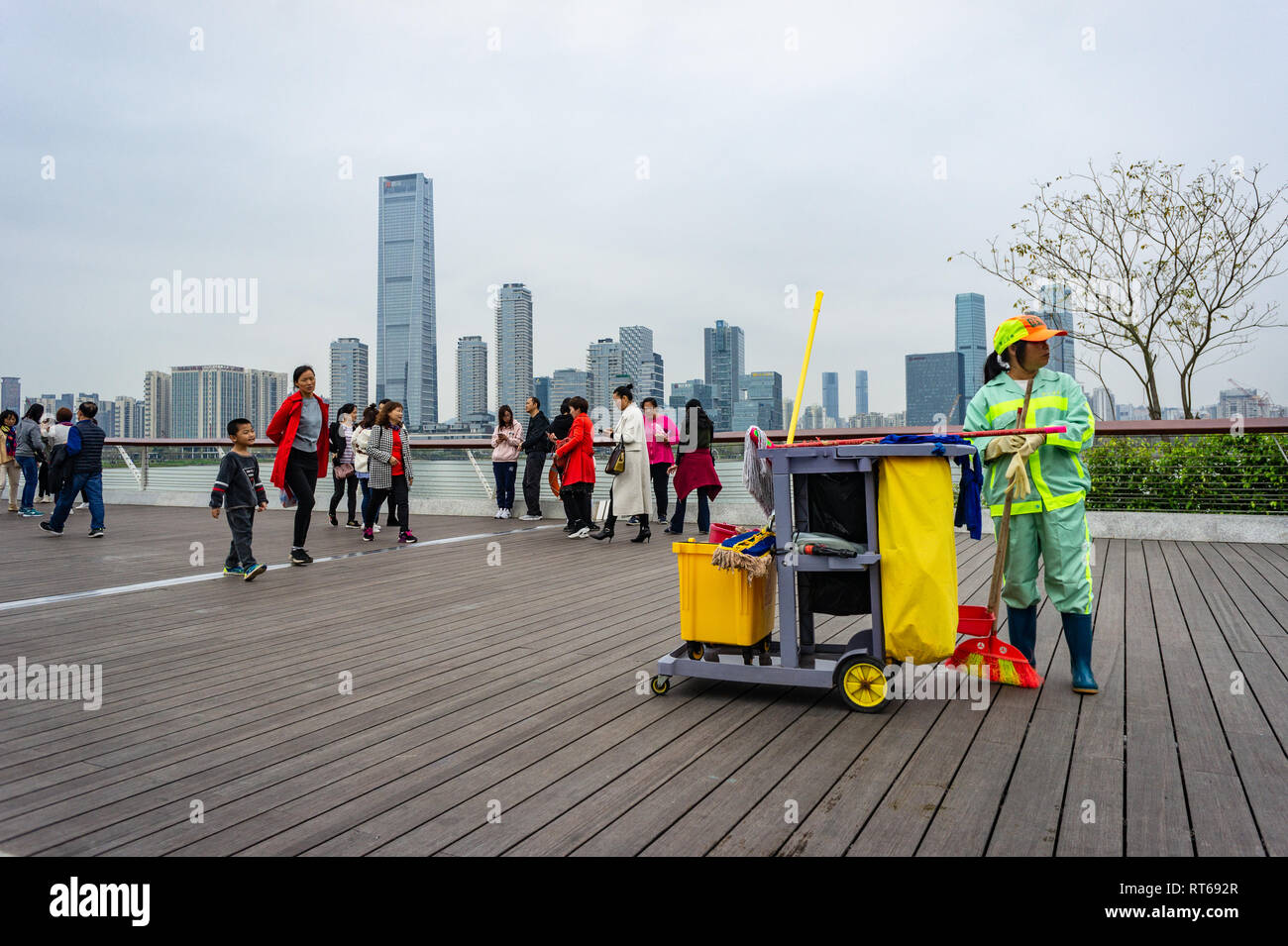 Cleaning lady in uniform in China near her equipment cart in foreground ...