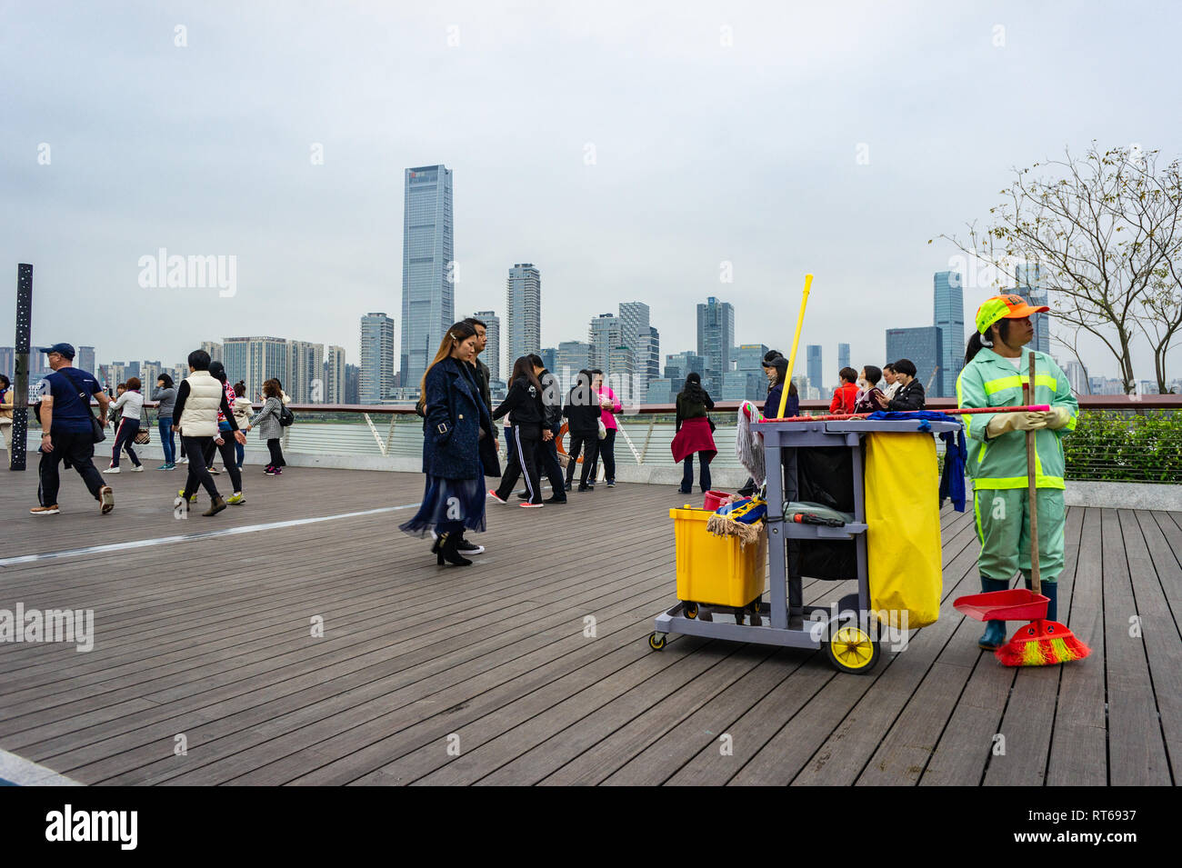 Cleaning lady in China near her equipment cart in foreground against ...