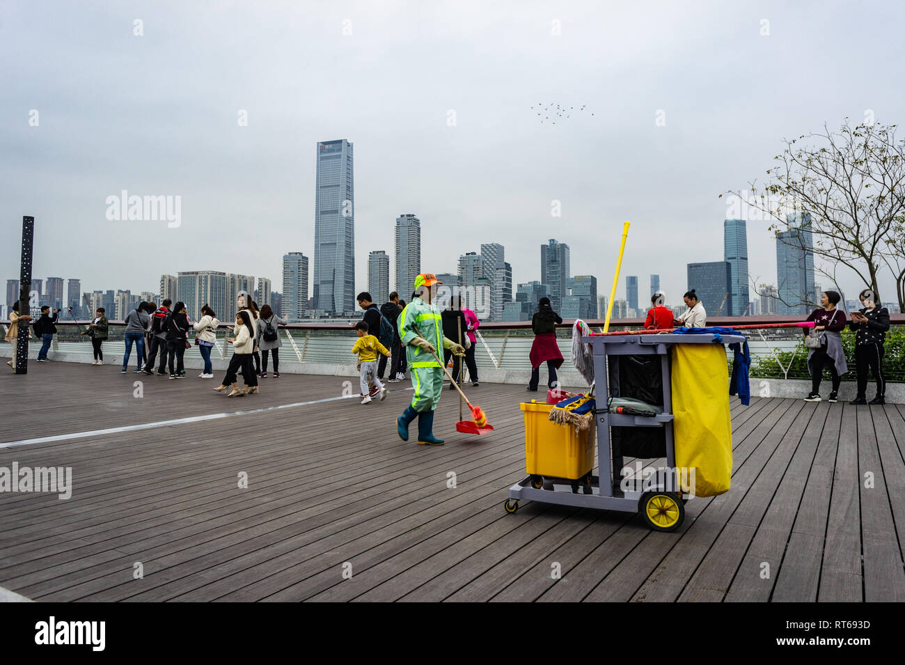 Cleaner in China near her equipment cart in foreground against Chinese ...