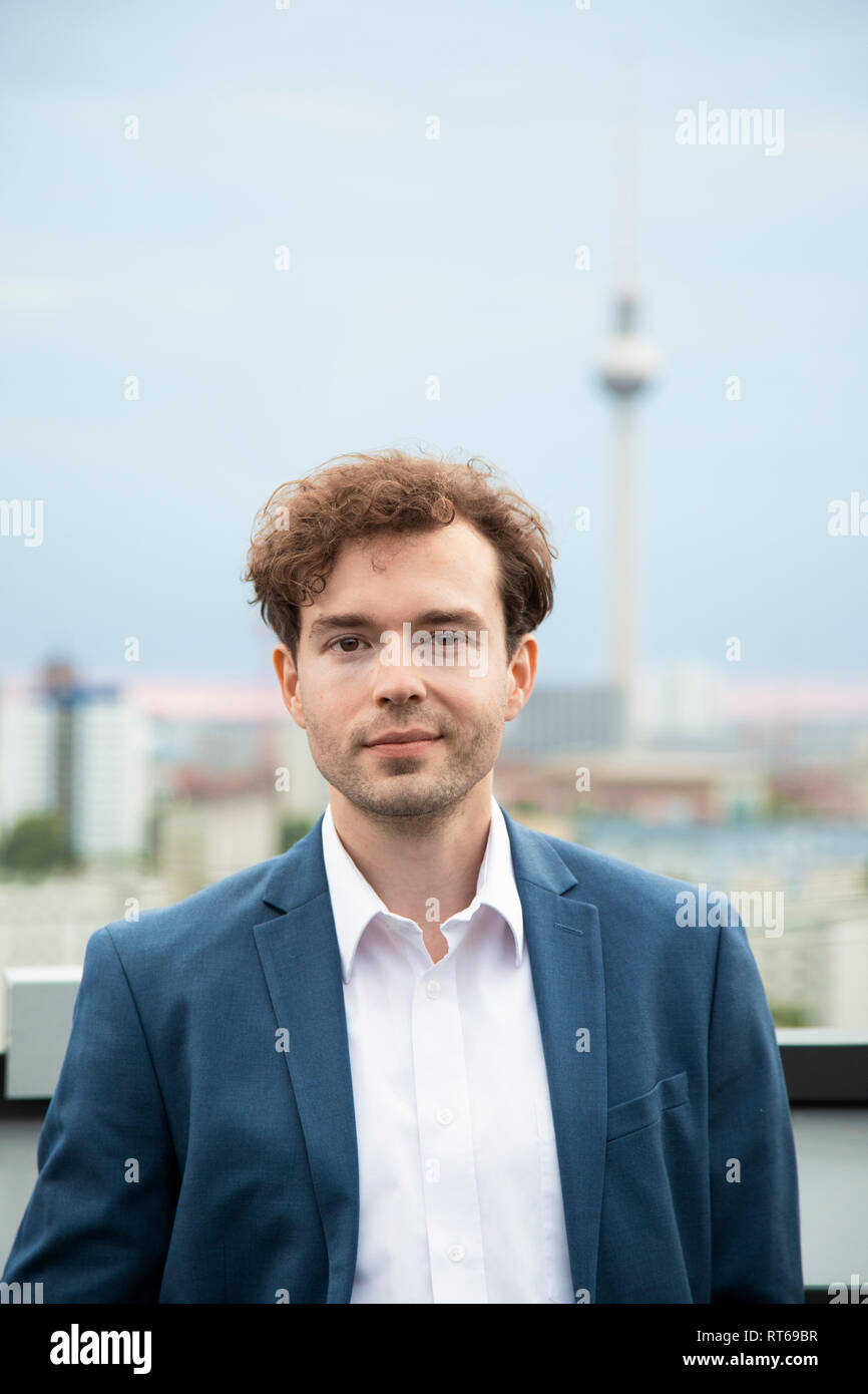 Germany, Berlin, portrait of businessman with stubble and curly brown ...