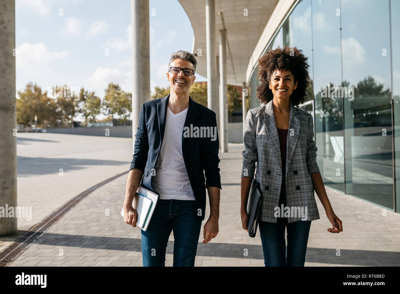 Portrait of two happy colleagues outside office building Stock Photo ...