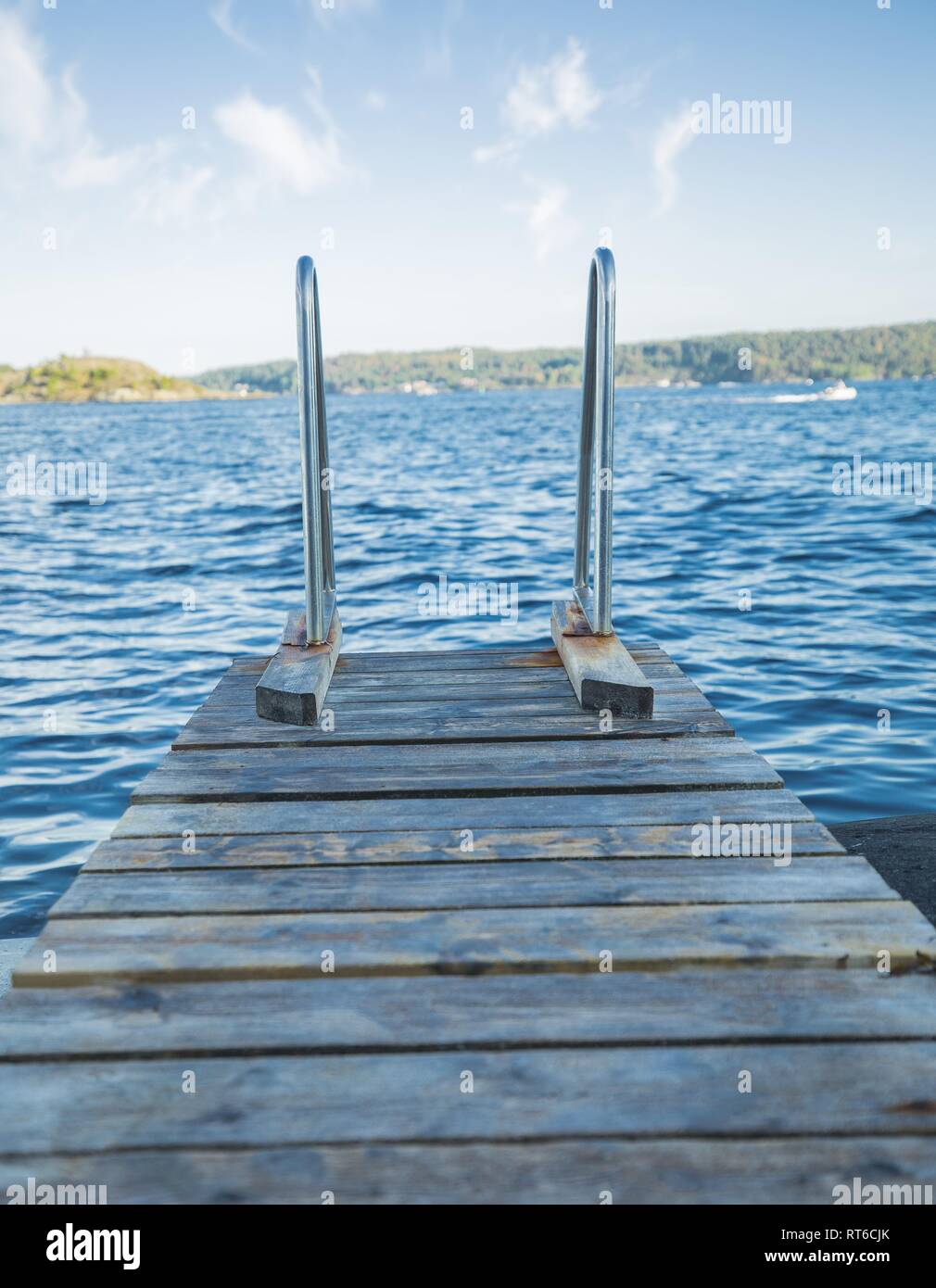 wooden pier, blue water and clear sky in the summer Stock Photo - Alamy