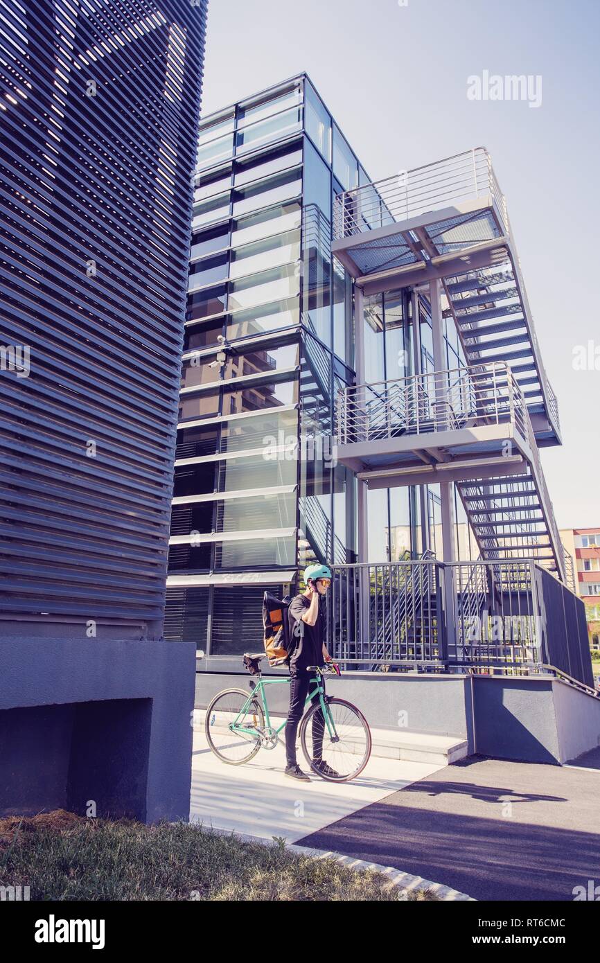 Bike messenger with huge backpack in the city Stock Photo - Alamy