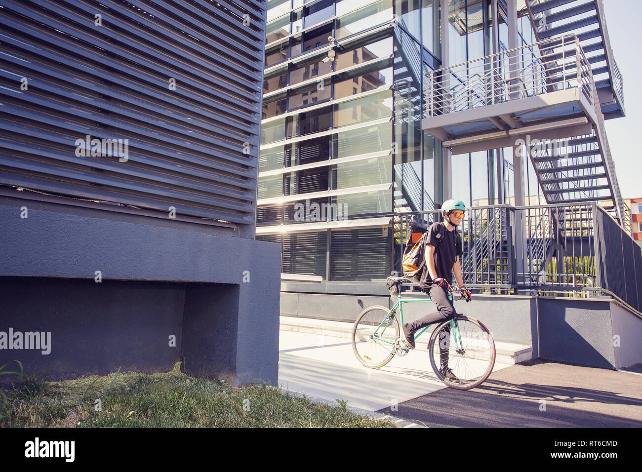 Bike messenger with huge backpack in the city Stock Photo - Alamy