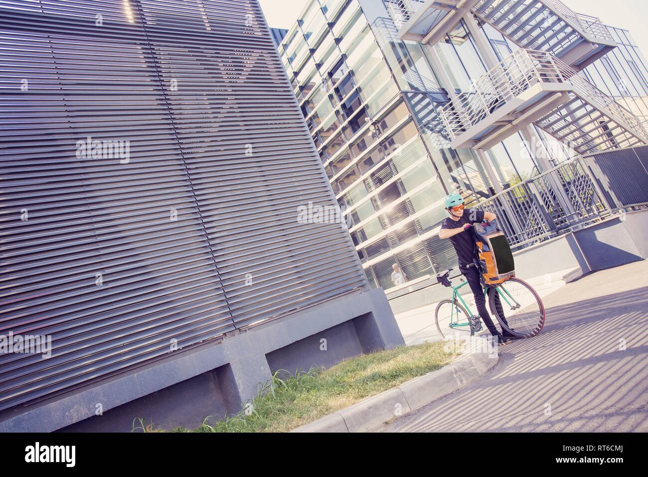 Bike messenger with huge backpack in the city Stock Photo - Alamy