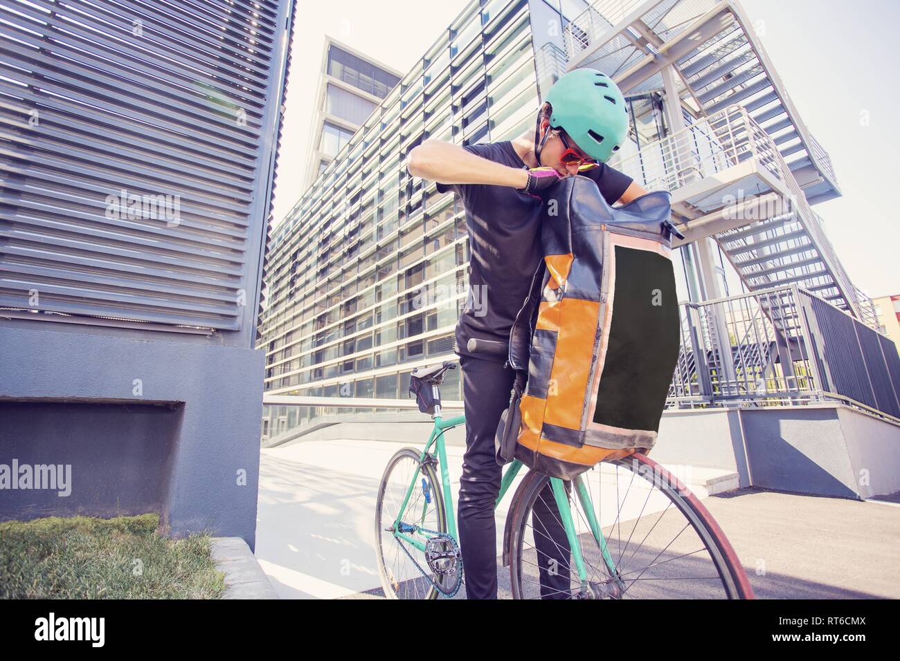 Bike messenger with huge backpack in the city Stock Photo - Alamy