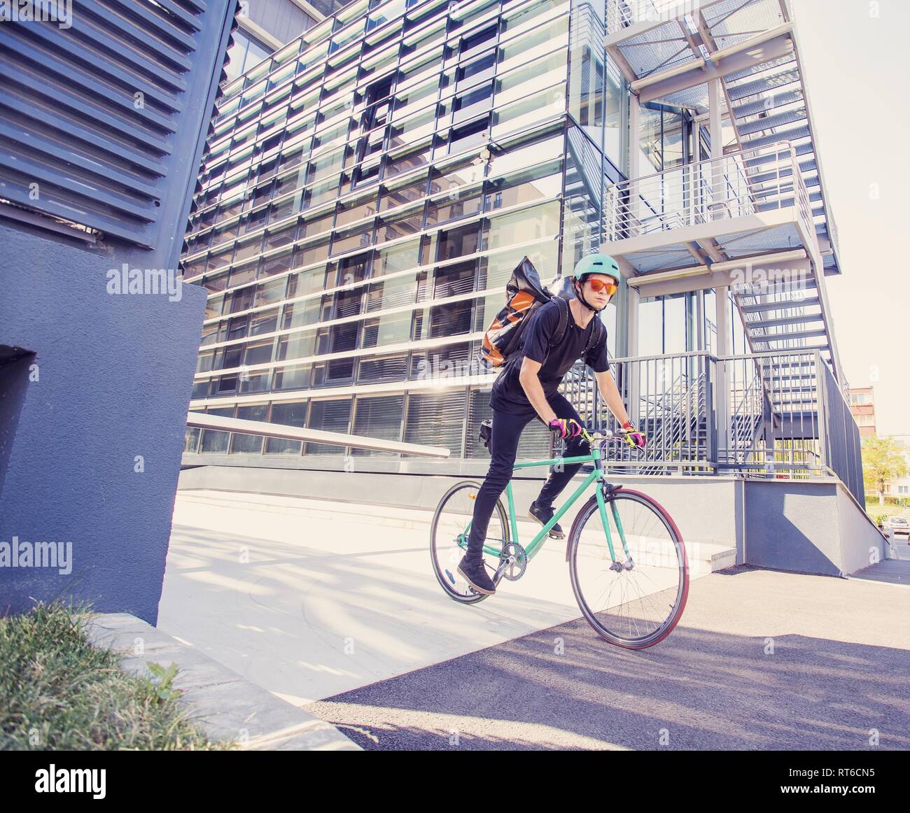 Bike messenger with huge backpack in the city Stock Photo - Alamy