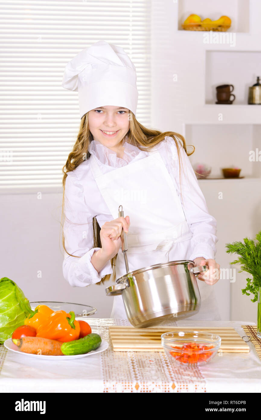Portrait of beautiful girl wearing chef uniform cooking on kitchen ...
