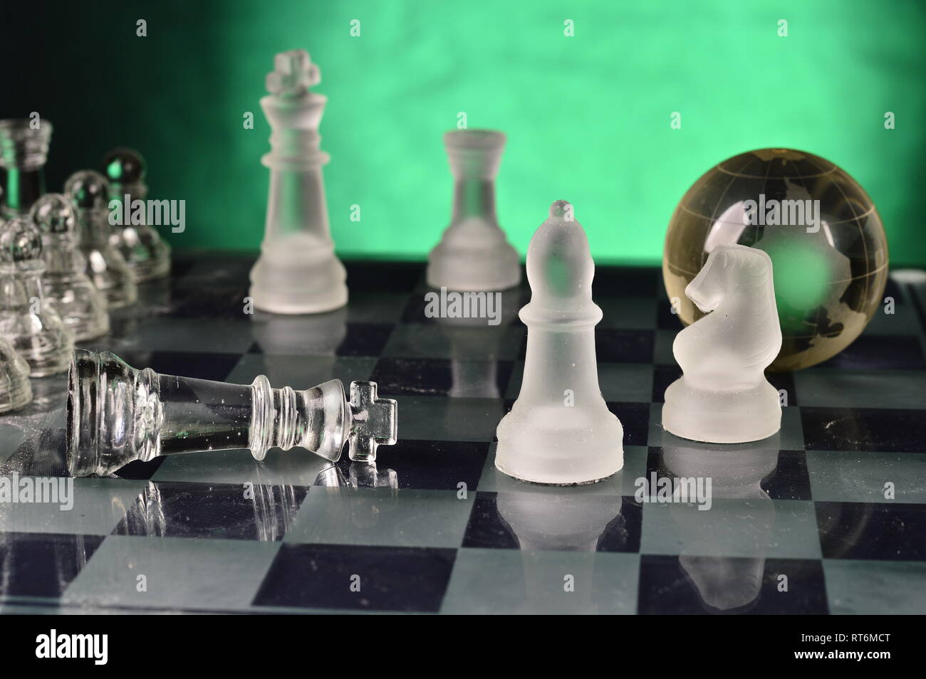 Glass pieces of Chess Game on the chessboard with green background ...