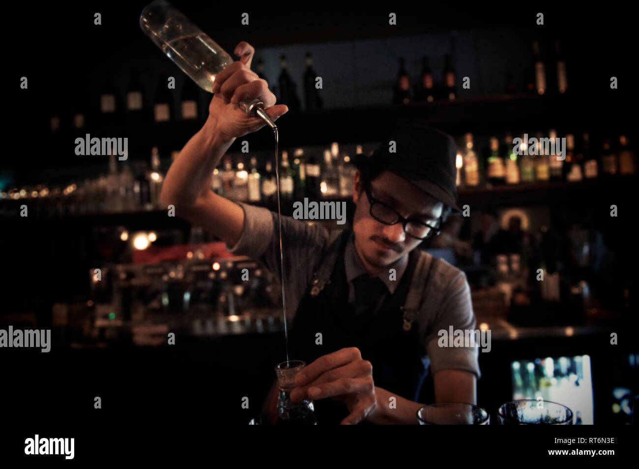 A talented professional mixologist bartender pours cocktails for ...
