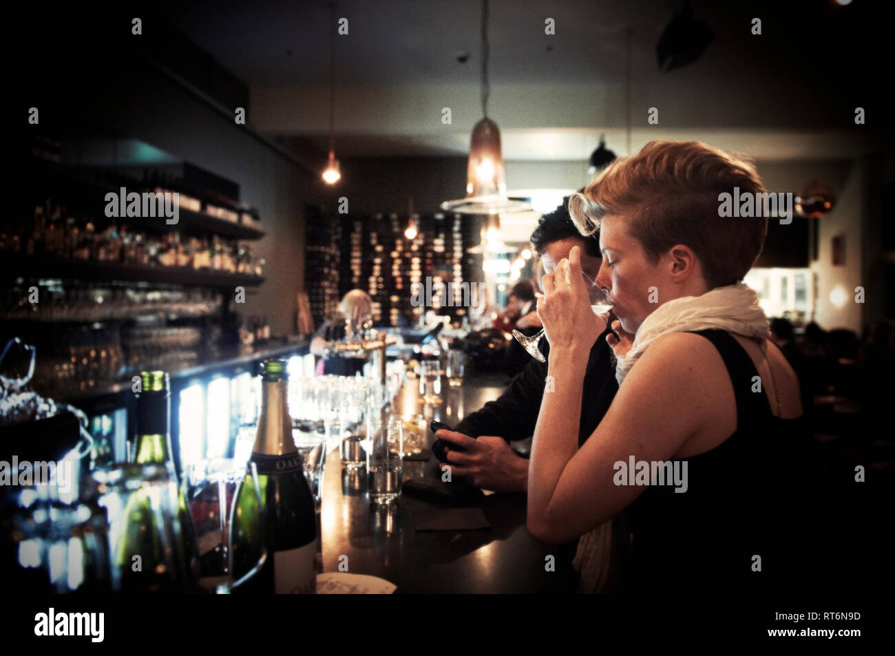 Patrons in a busy bar enjoy an alcoholic beverage Stock Photo - Alamy