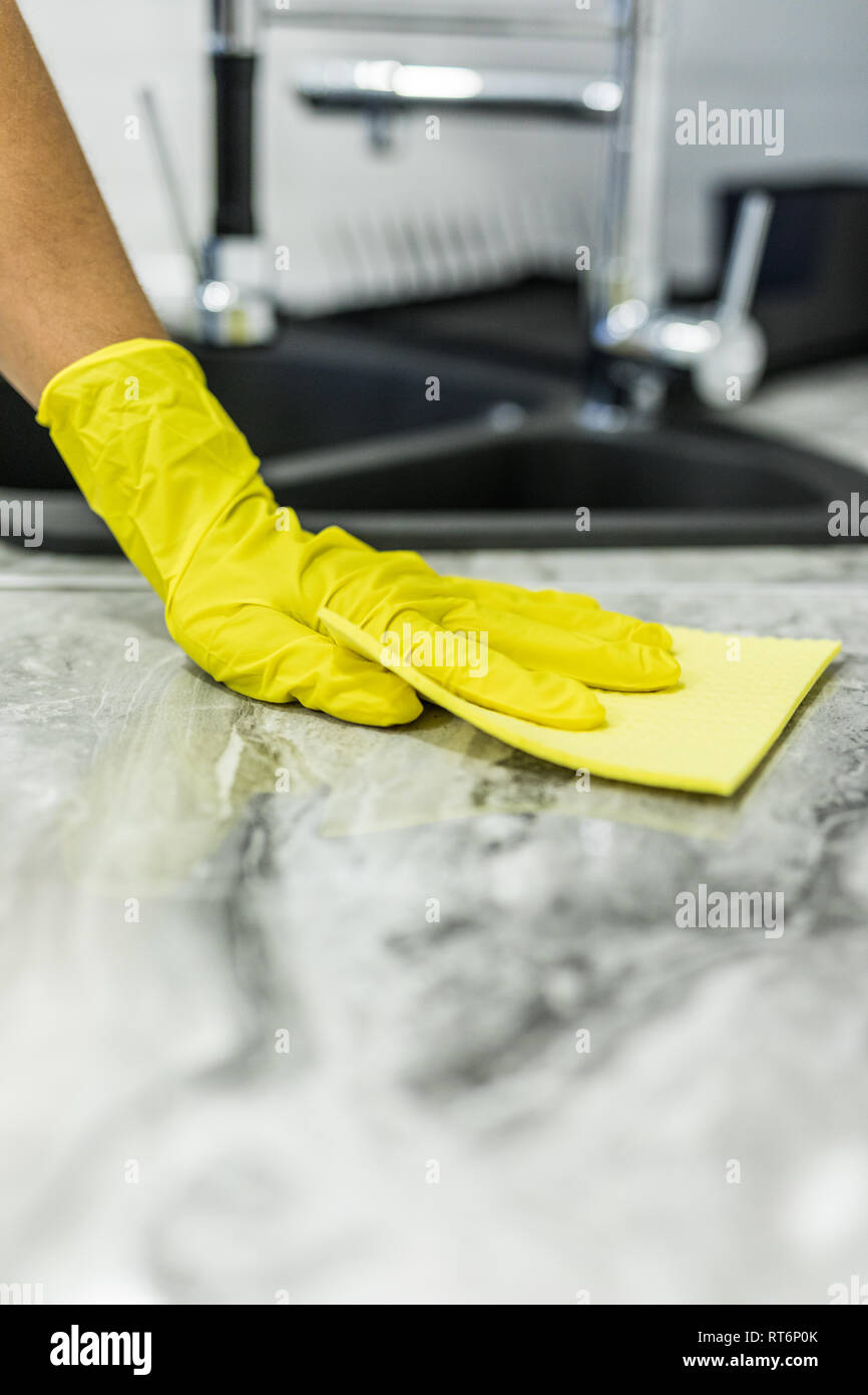 Cropped image of male janitor cleaning counter with detergent spray ...