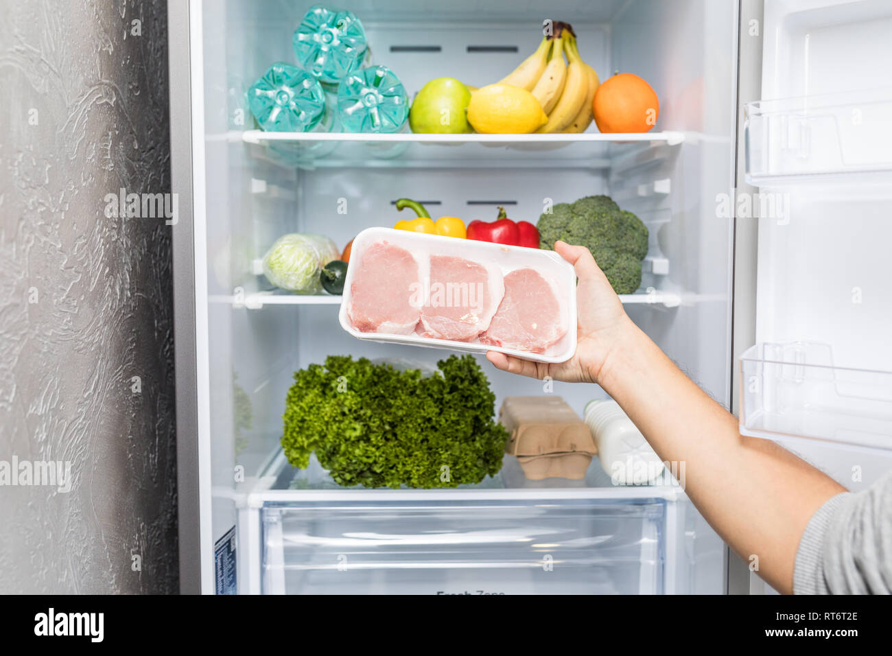 Hands take meat standing next to the open fridge Stock Photo - Alamy
