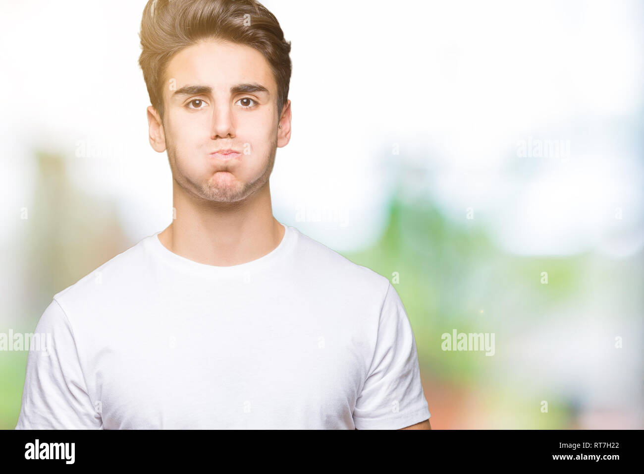 Young handsome man wearing white t-shirt over isolated background ...