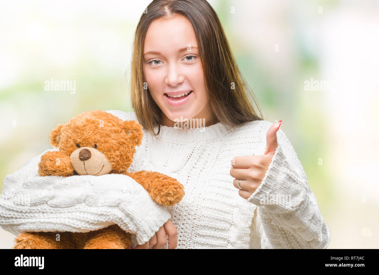 Young caucasian woman holding teddy bear over isolated background happy ...