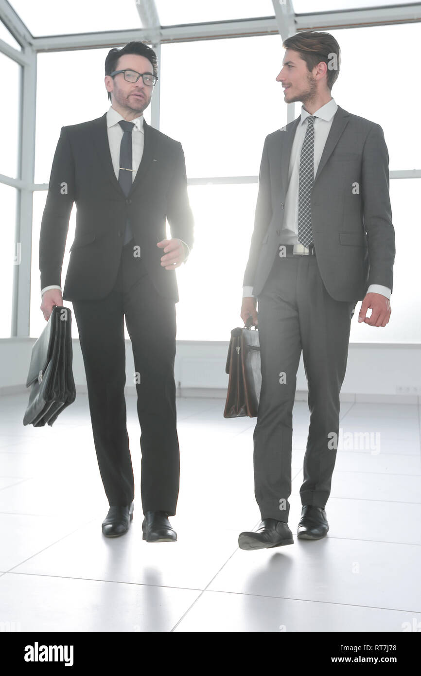 two businessmen talking in the lobby of the office Stock Photo - Alamy