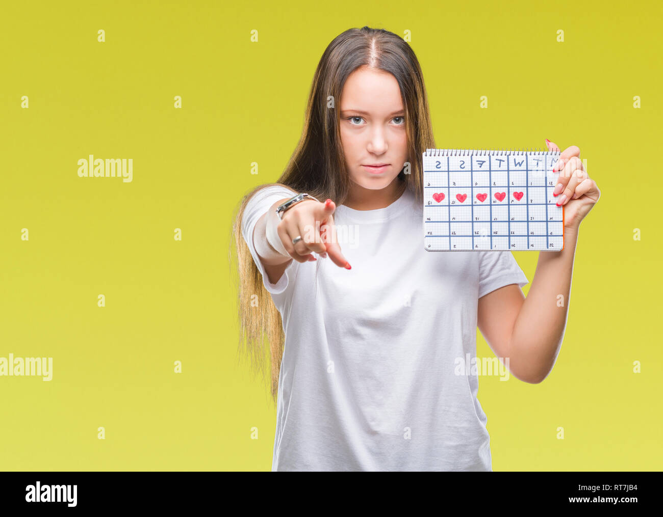 Young caucasian woman holding menstruation calendar over isolated ...