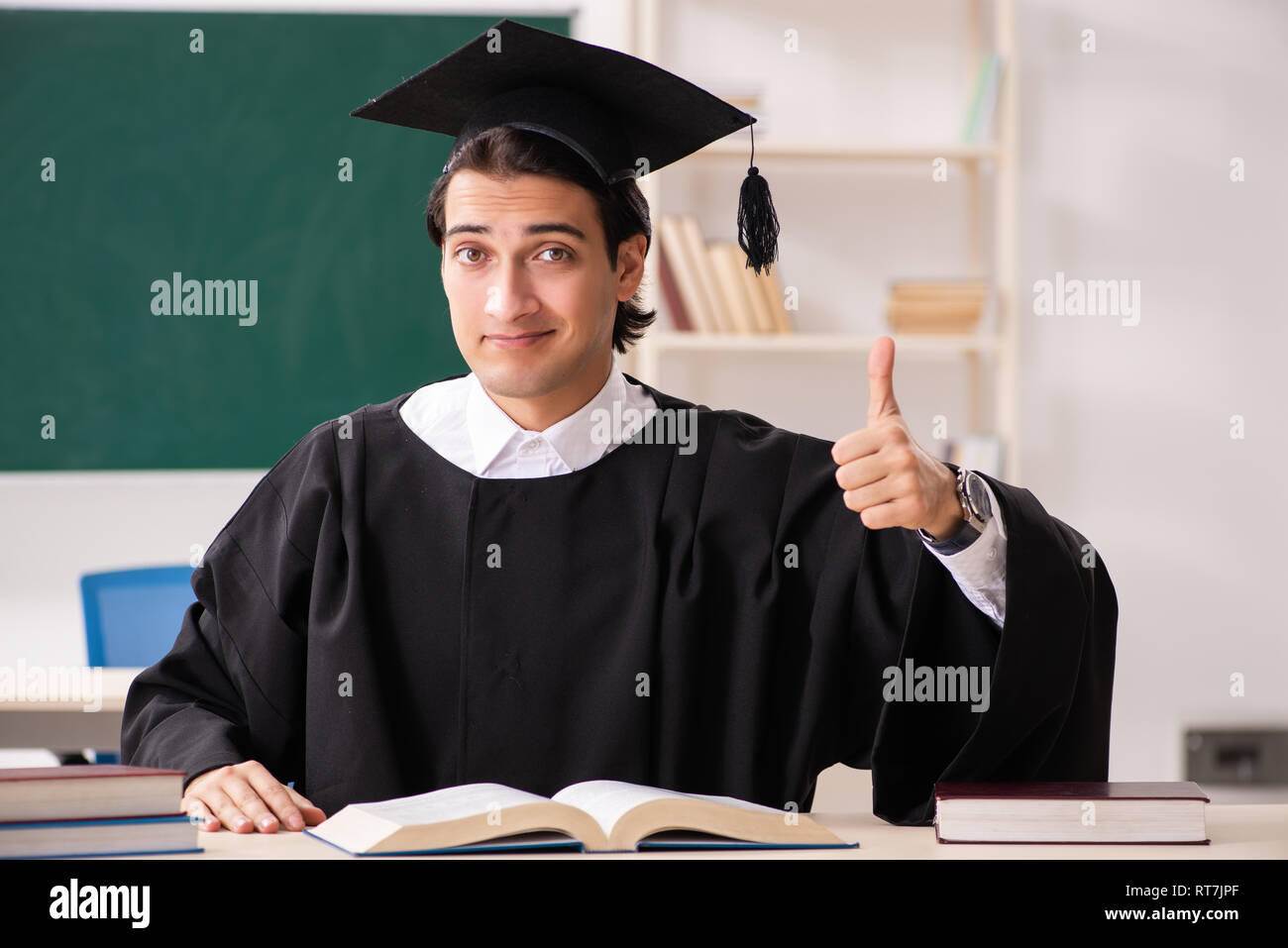 Graduate student in front of green board Stock Photo - Alamy