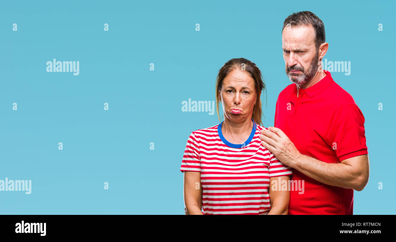 Middle age hispanic couple in love over isolated background depressed ...