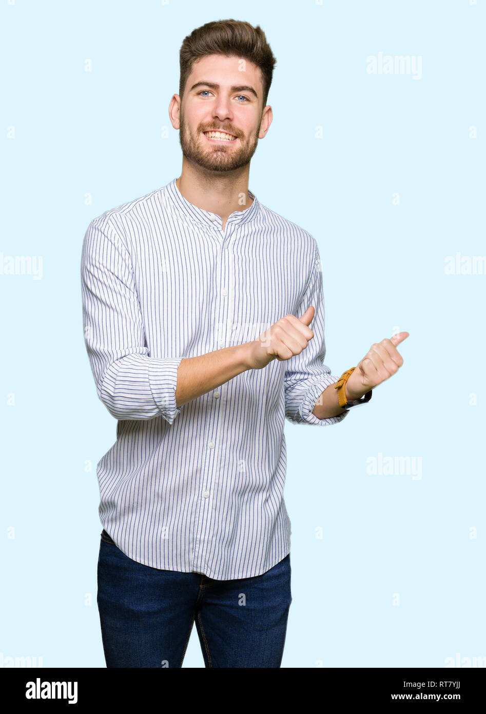 Young handsome man Pointing to the back behind with hand and thumbs up ...