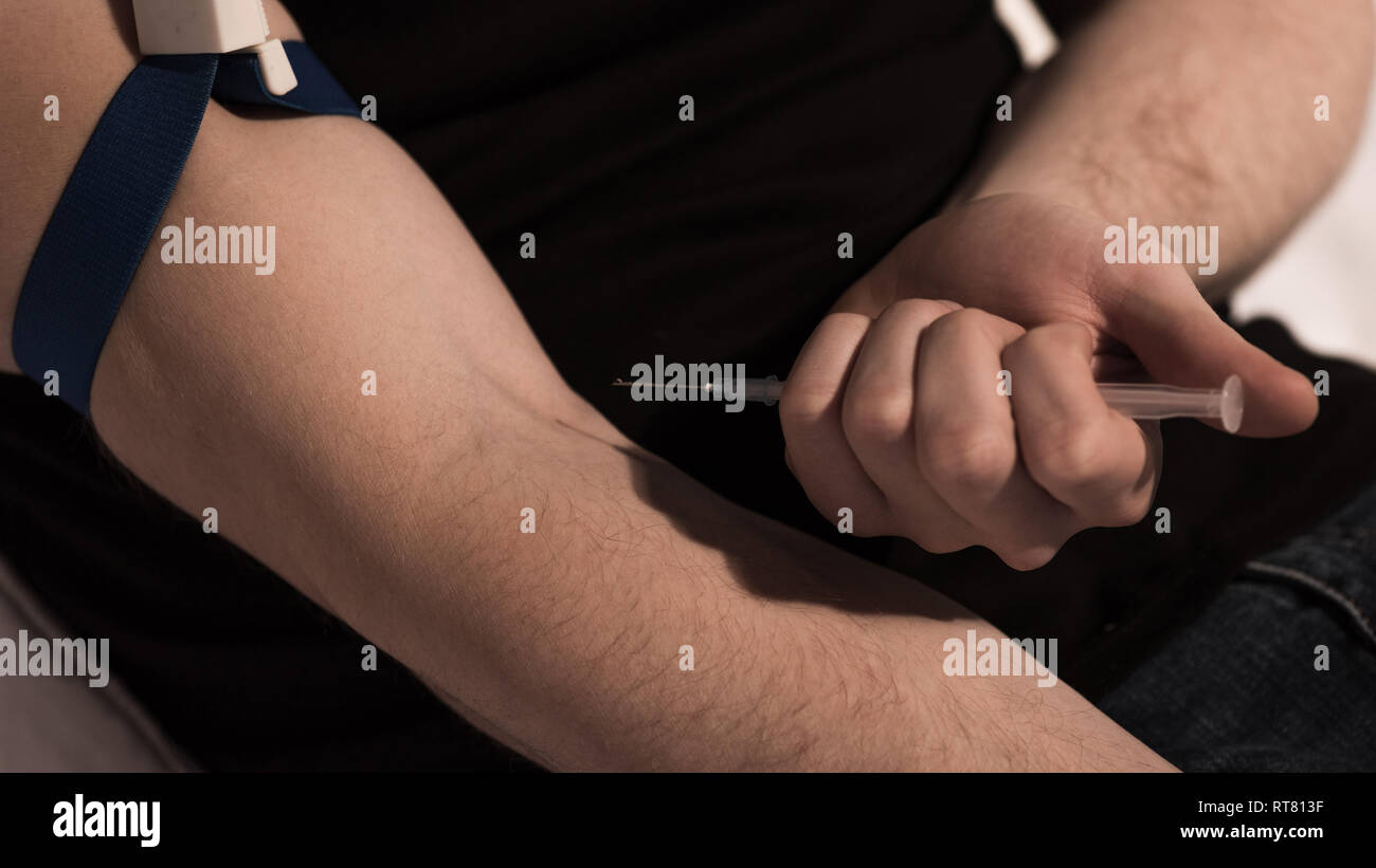 selective focus of junkie man making injection of heroin dose Stock ...