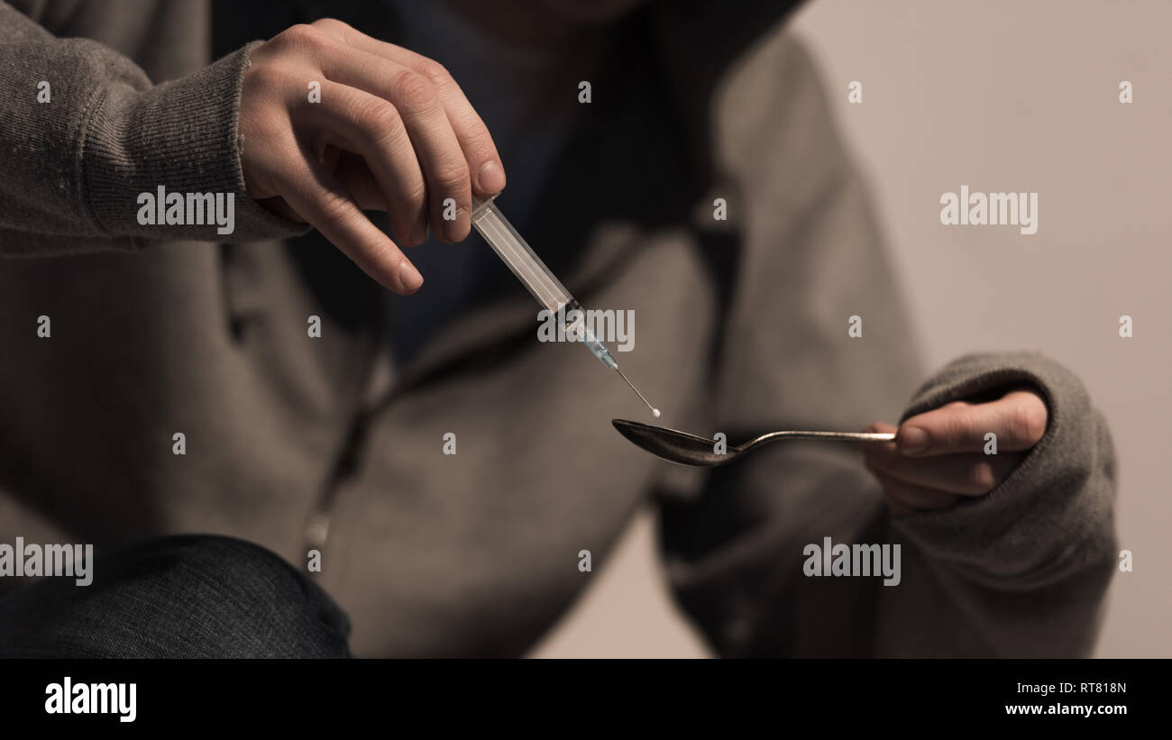 selective focus of addict man filling syringe with heroin Stock Photo ...