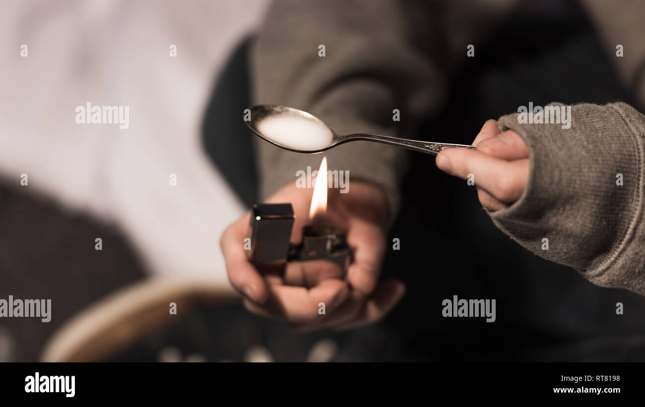 selective focus of addict man boiling heroin in spoon on lighter Stock ...