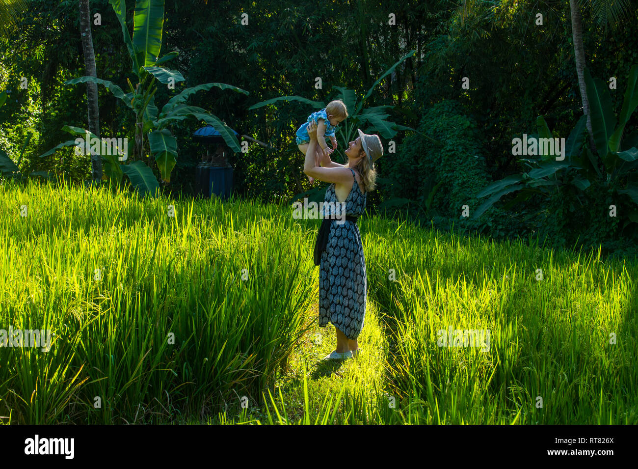 Indonesia, Bali, Ubud, Woman with her baby girl in the rice paddies ...