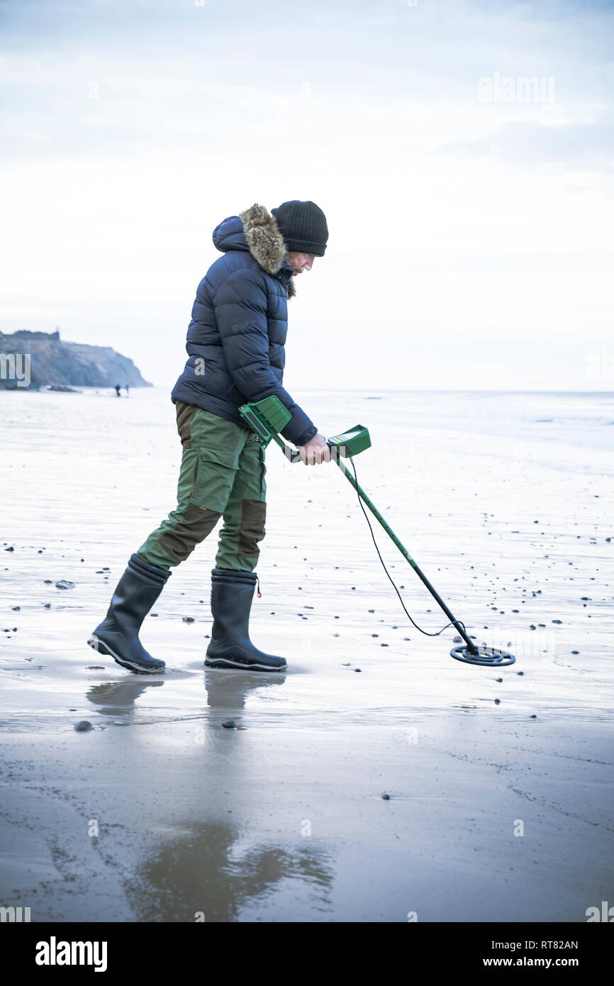 Man with metal detector at the sand beach Stock Photo - Alamy