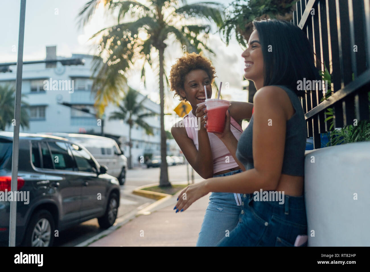USA, Florida, Miami Beach, two happy female friends having a soft drink ...