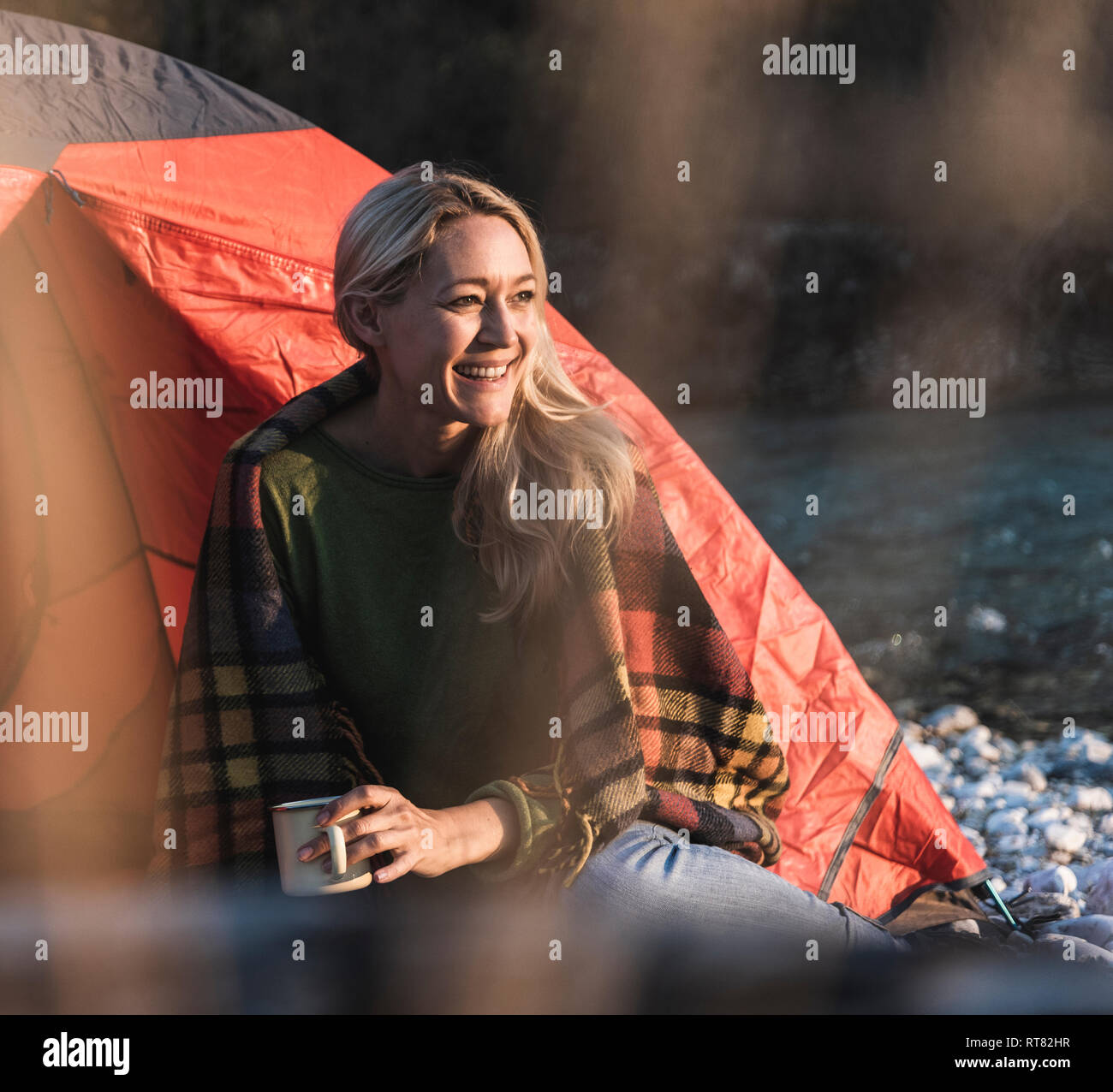 Mature woman camping, sitting in front of tent Stock Photo - Alamy