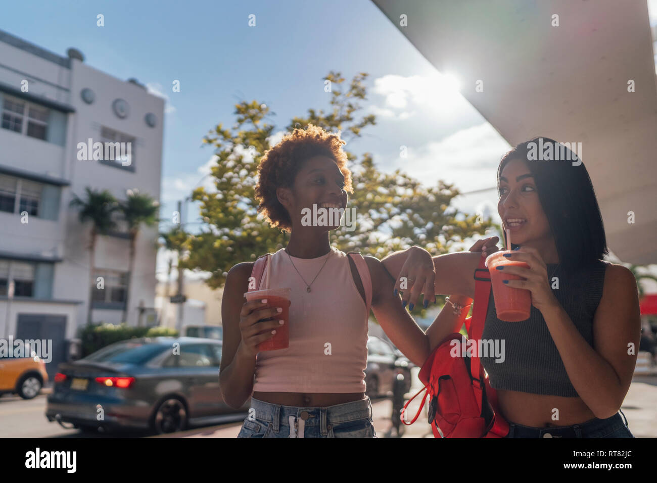USA, Florida, Miami Beach, two happy female friends having a soft drink ...