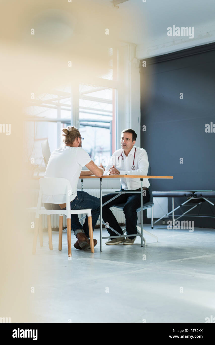 Doctor talking to patient in medical practice Stock Photo - Alamy