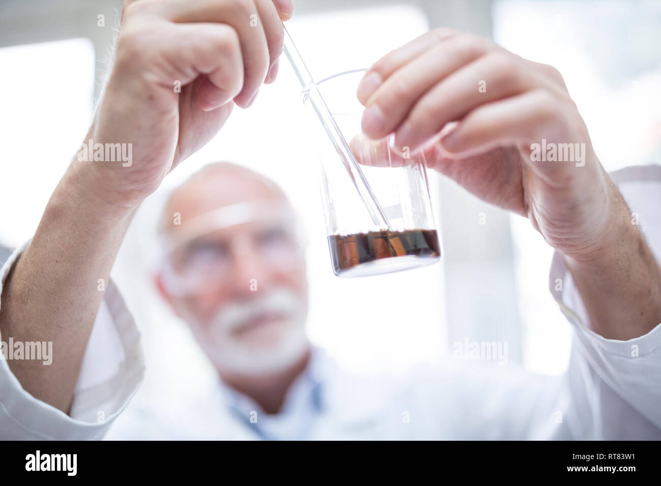 Man holding beaker in laboratory Stock Photo - Alamy