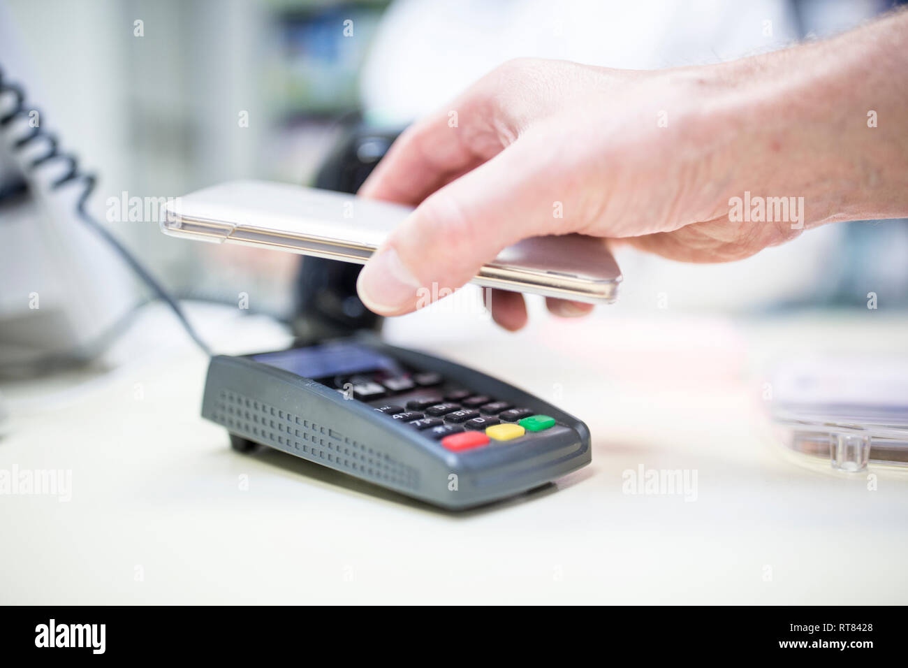 Mobile payment at shop counter Stock Photo - Alamy