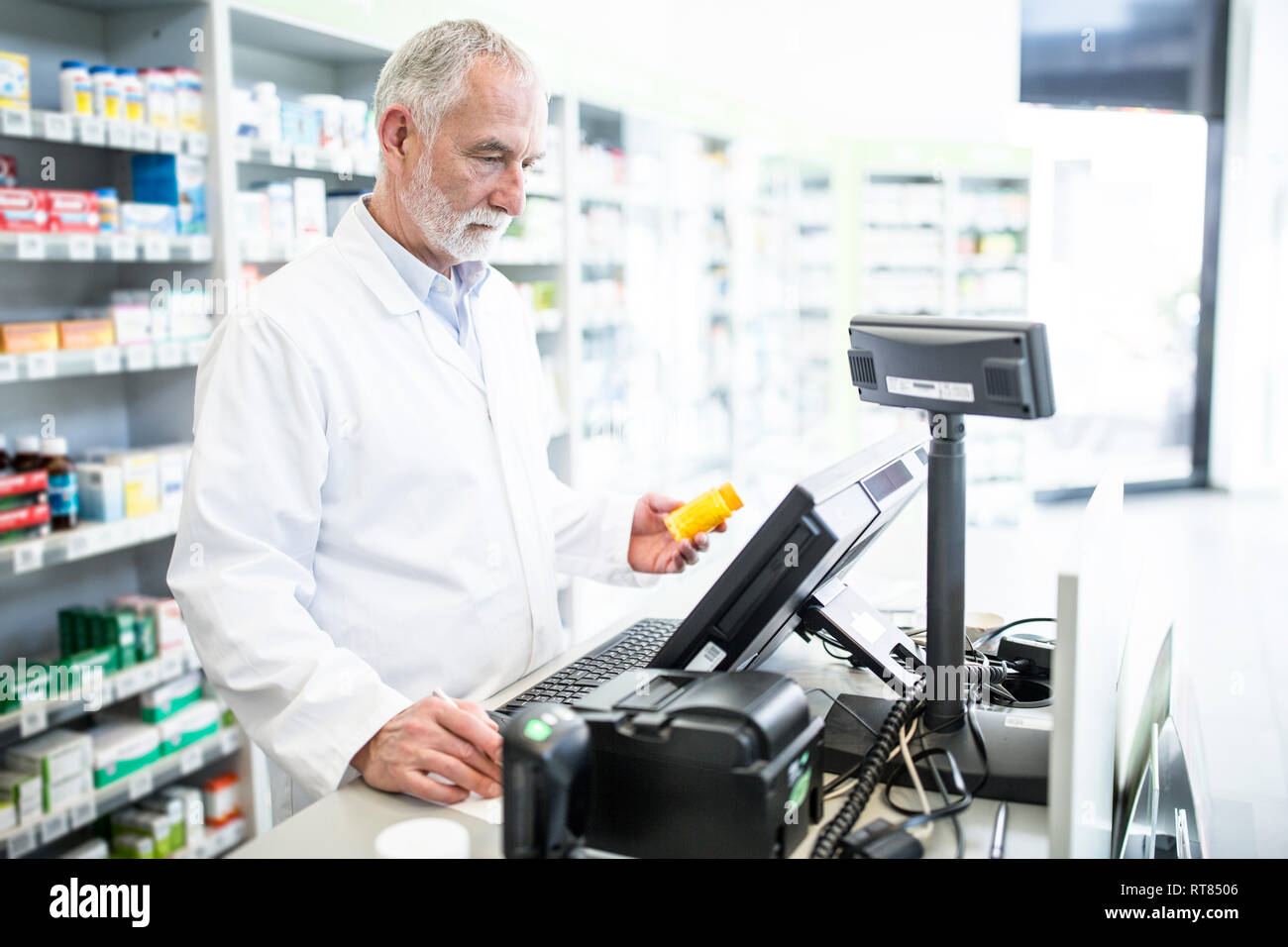 Pharmacist with medicine at counter in pharmacy Stock Photo - Alamy