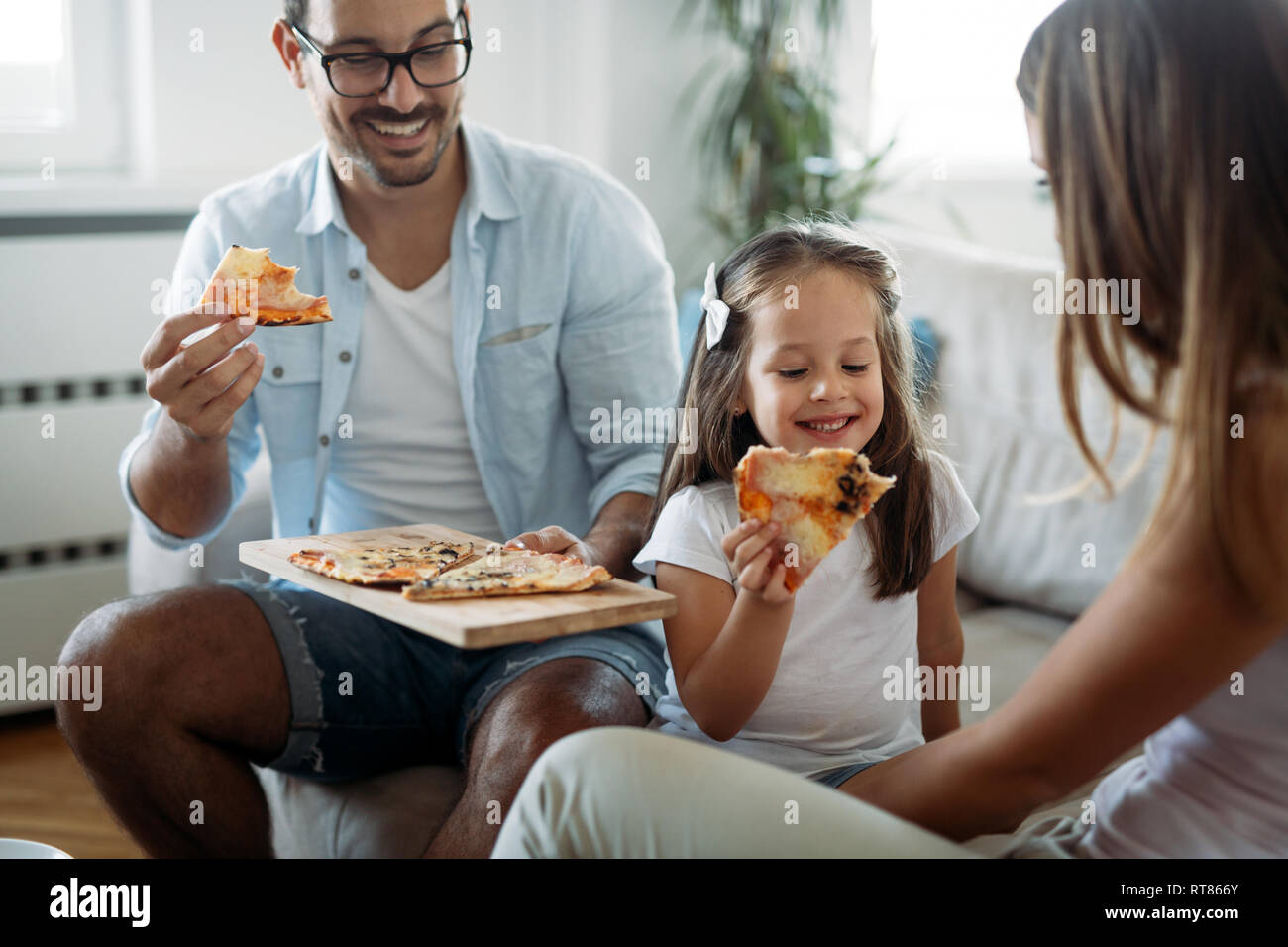 Portrait of happy family sharing pizza at home Stock Photo - Alamy