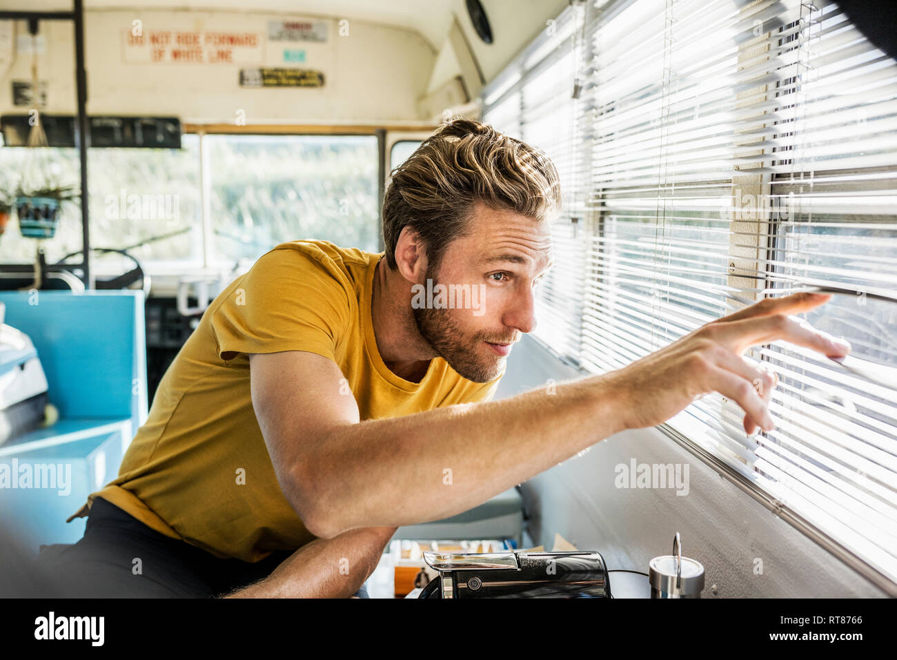 Man in an old bus peeking through sunblind Stock Photo - Alamy