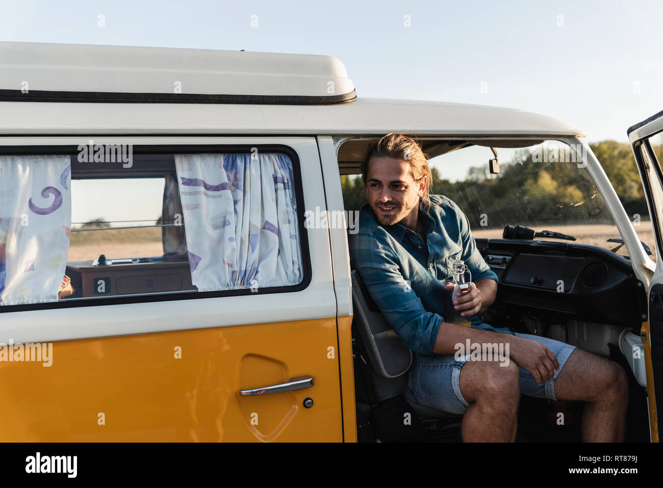 Young man on a road trip with his camper, taking a break Stock Photo ...