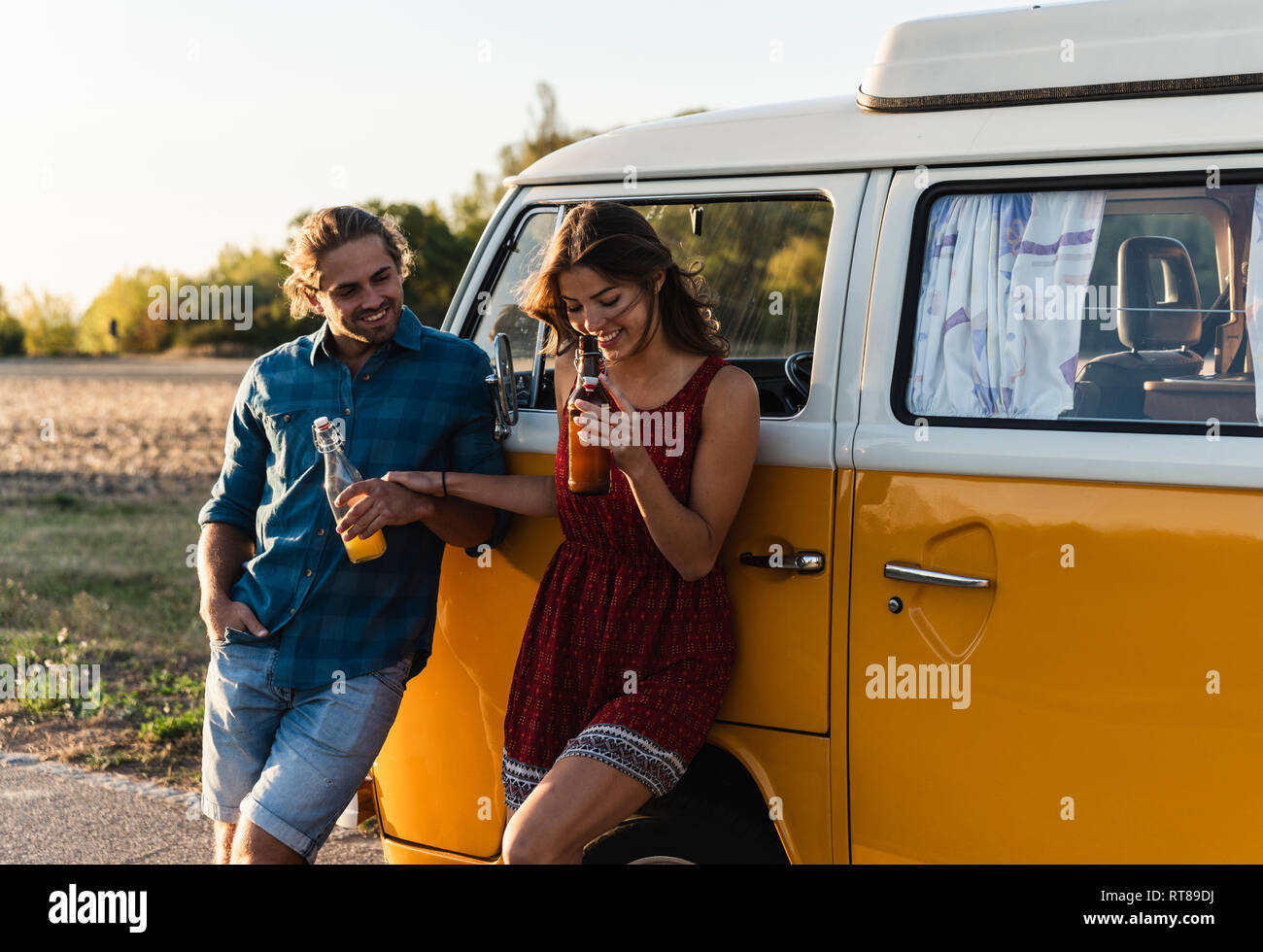 Happy couple taking a break on their road trip, having a drink Stock ...