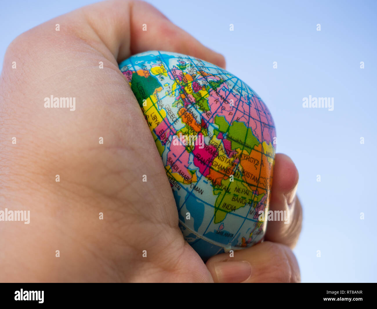 A person destroying with his hand a terrestrial globe or planet earth ...