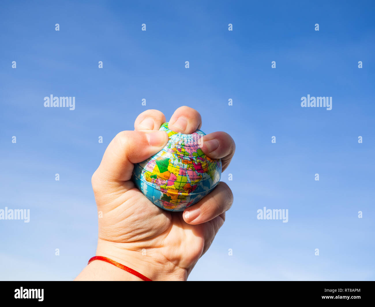 A person destroying with his hand a terrestrial globe or planet earth ...