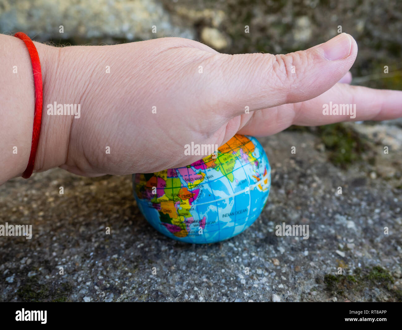 A person destroying with his hand a terrestrial globe or planet earth ...